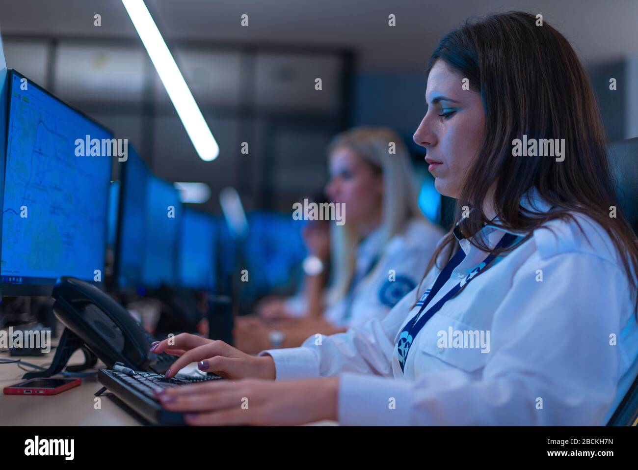 Happy security data center operator colleagues (coworkers) smiling and ...