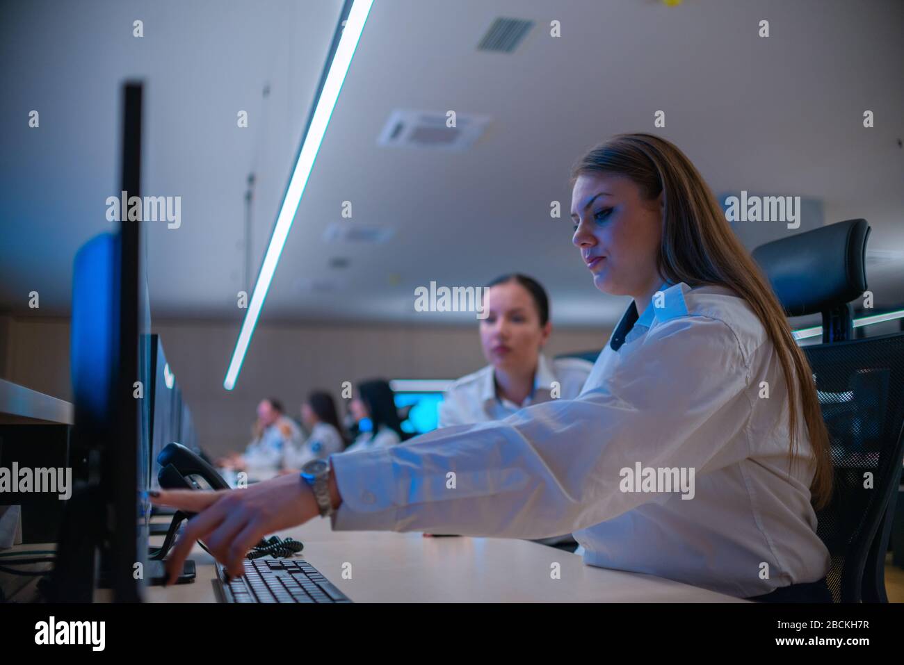 Close up photo of a security female agent monitoring the CCTV in a main ...