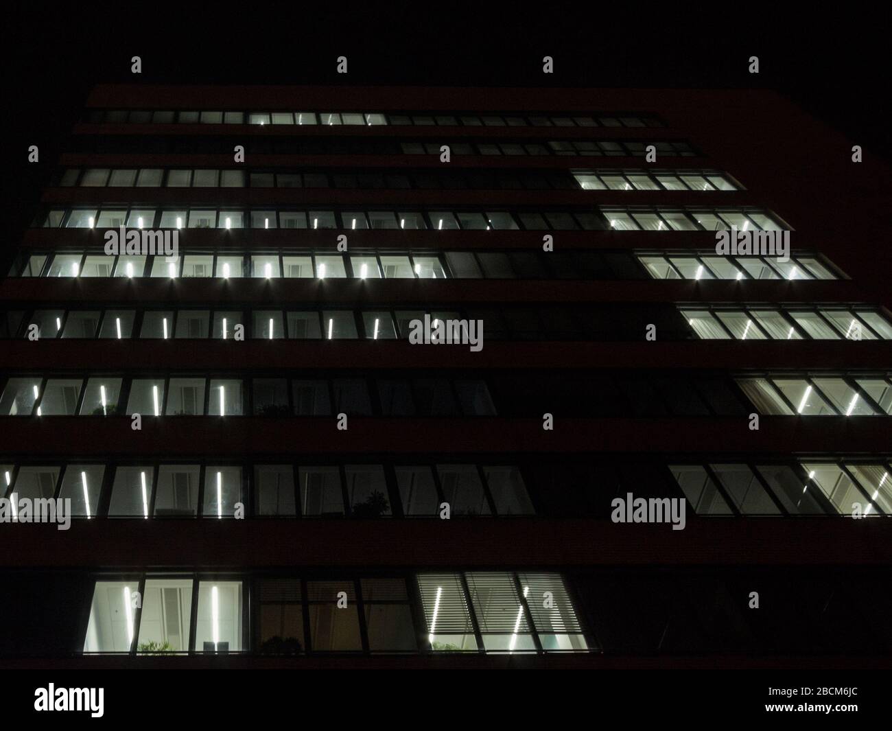 Facade of a business district building, a high rise, at night, in the ...