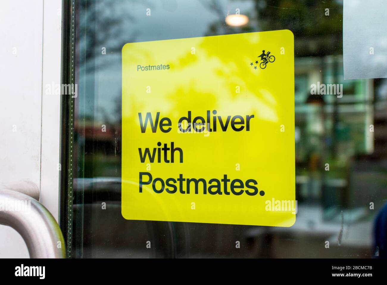 Close up. A yellow sticker decal on a restaurant door advertising ...