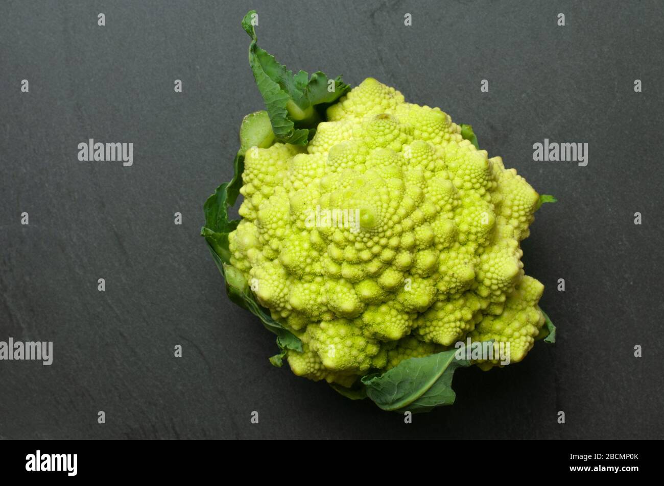 bright green flower head of a romanesco cauliflower with spiral pattern ...