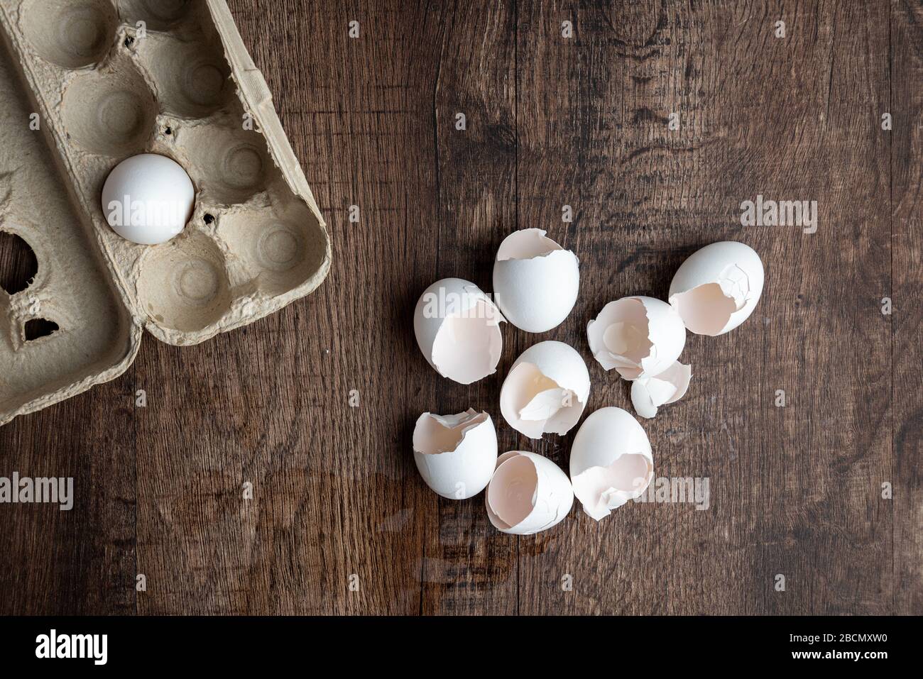 Eight eggshells, empty cardboard egg carton, wood table Stock Photo - Alamy