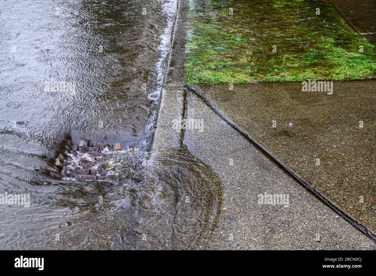 Heavy rain caused flooding in street, water swirling around storm drain ...