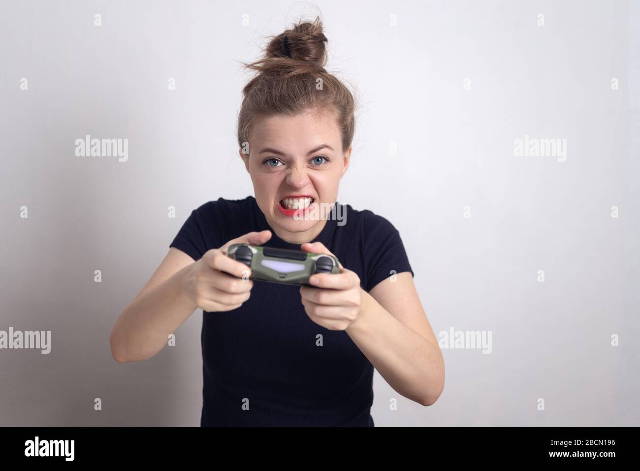 Angry young Caucasian woman girl holding joystick game pad controller ...
