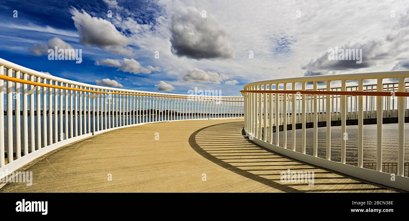 Curve of a white pedestrian footbridge by the Swan River, strong ...