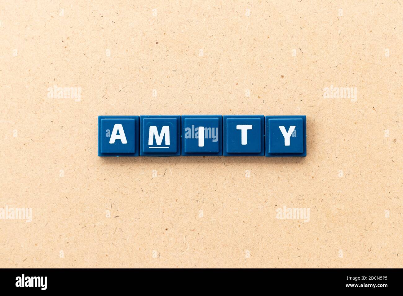 Tile letter in word amity on wood background Stock Photo - Alamy