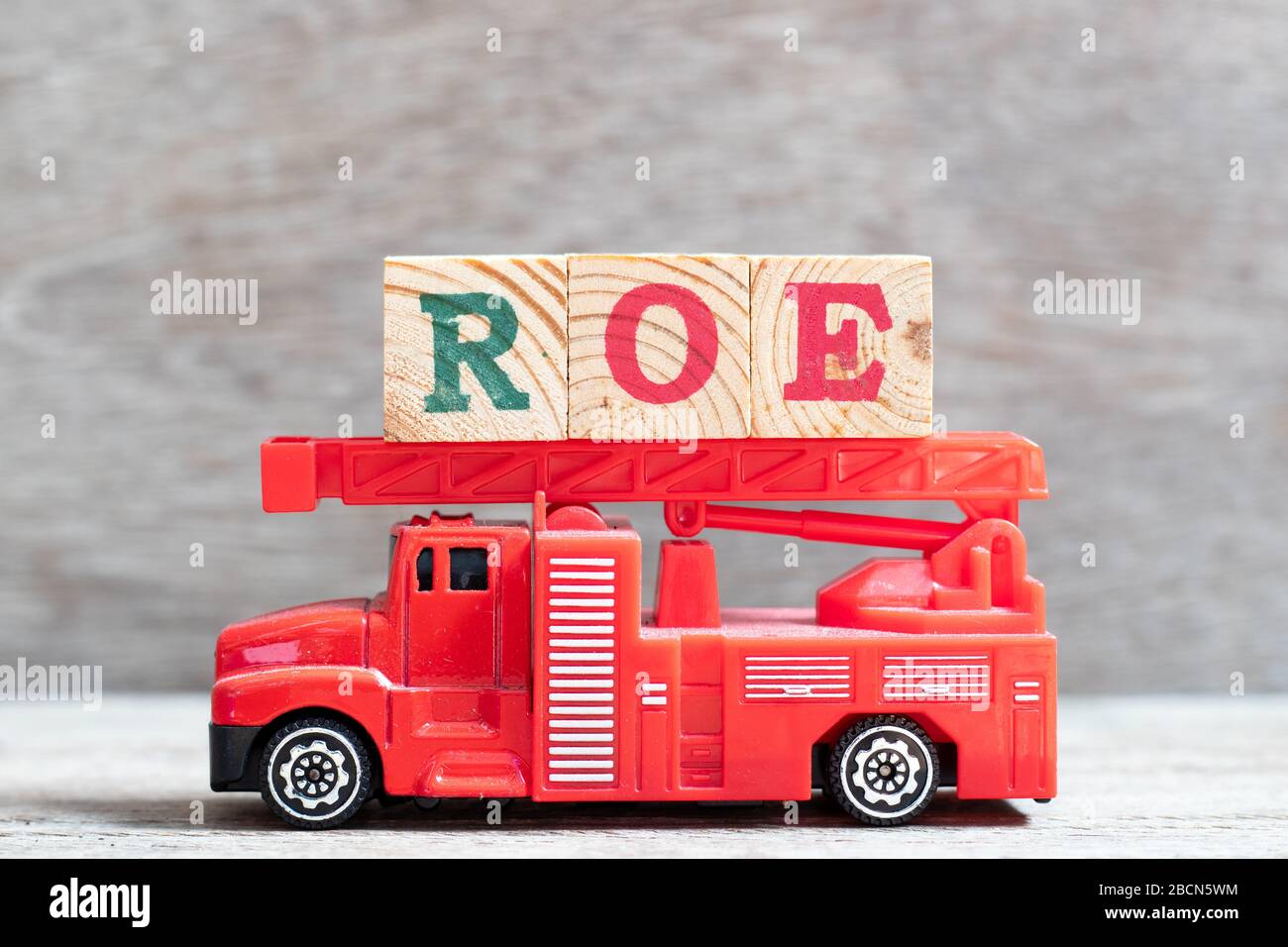 Red fire truck hold letter block in word ROE (Abbreviation of Return on ...