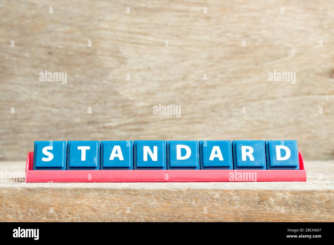 Tile letter on red rack in word standard on wood background Stock Photo ...