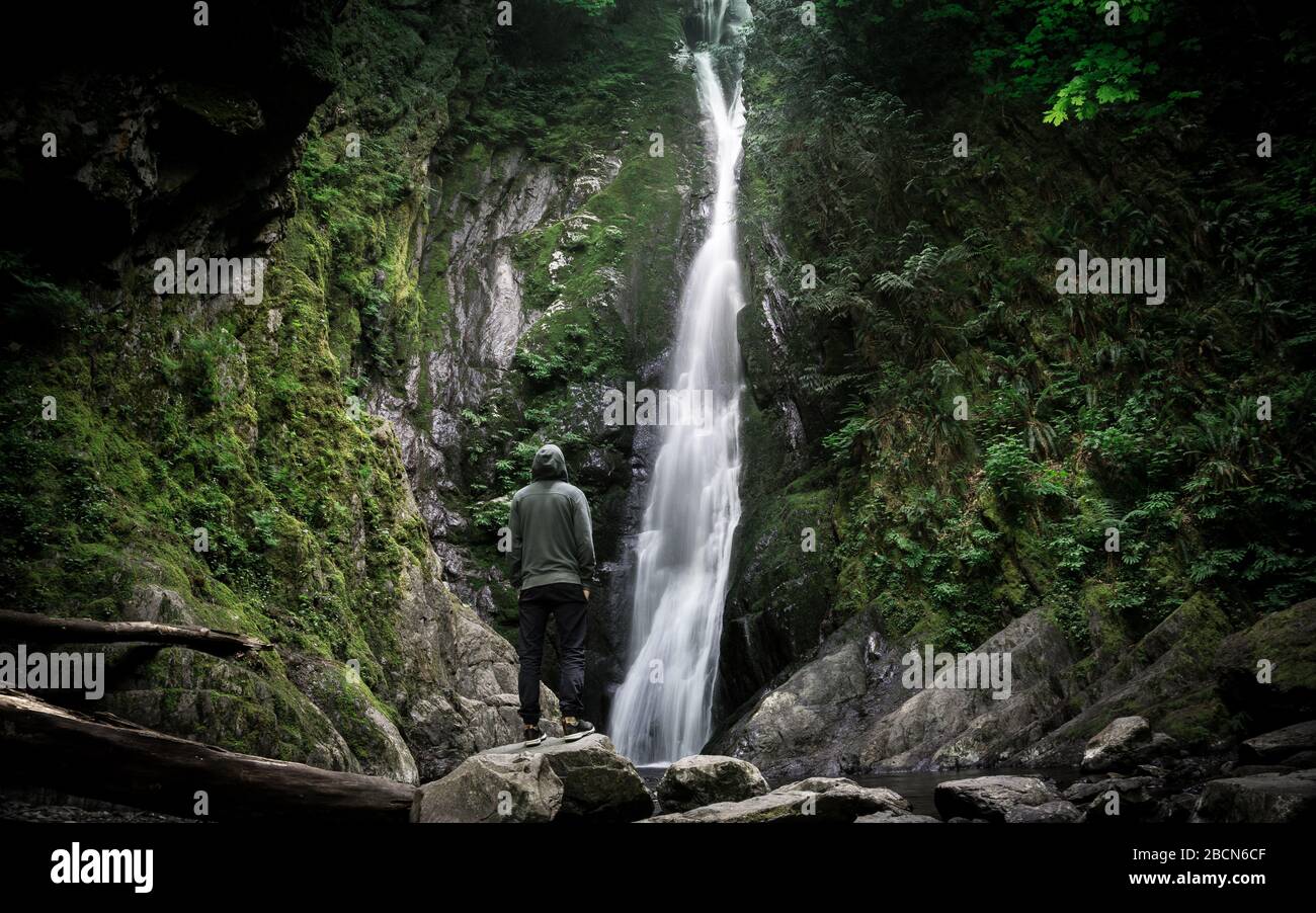 Man standing under falling waterfall on Vancouver Island in Canada BC ...
