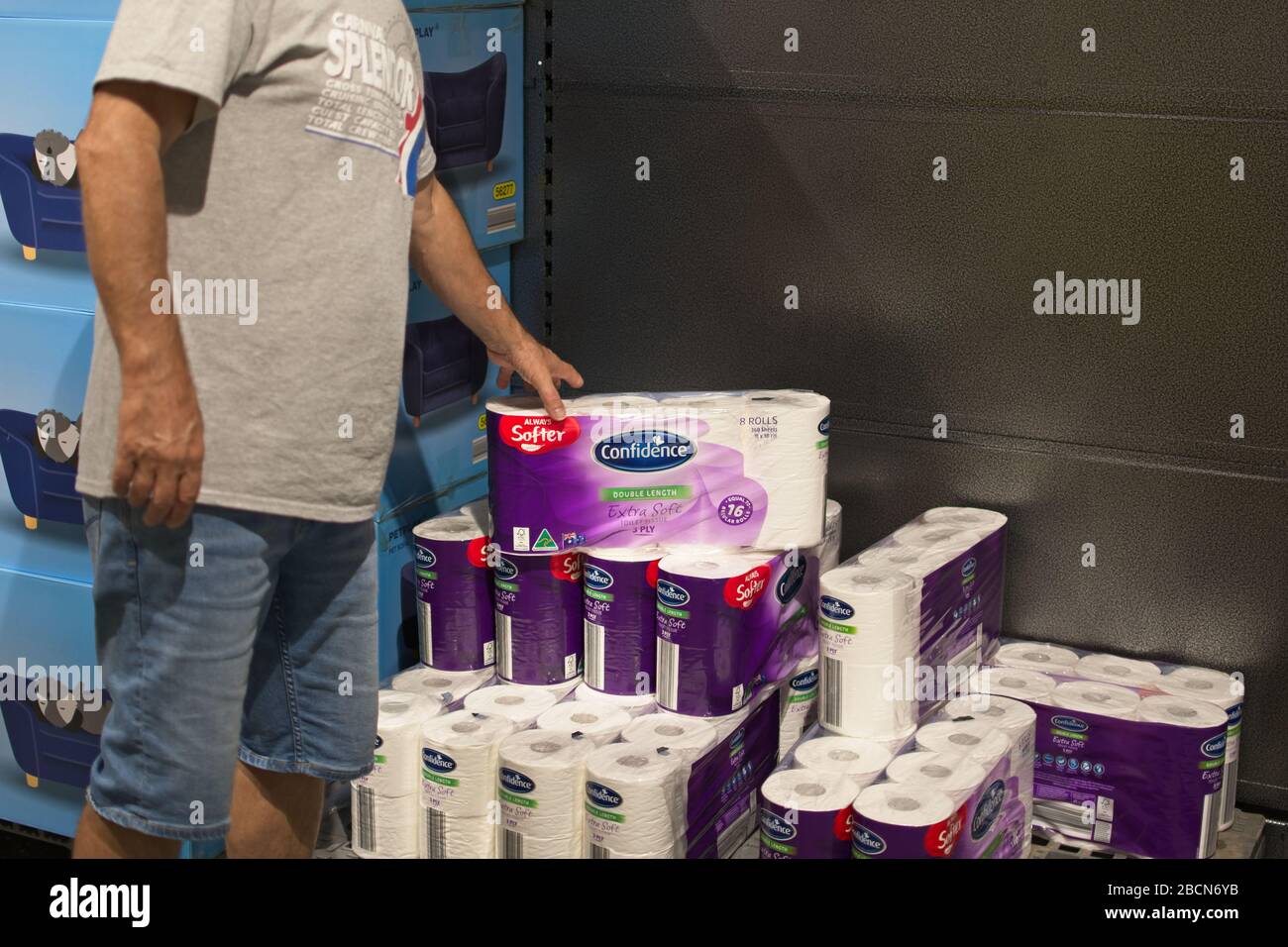 A customer grabs a packet of toilet paper Stock Photo - Alamy