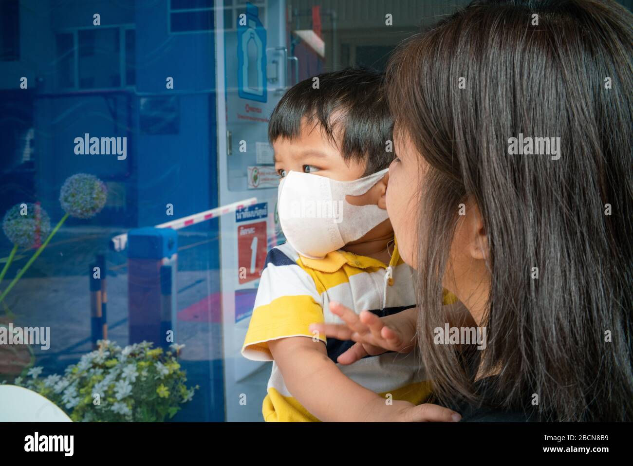 Asian cute boy and mother wearing N95 mask outdoor city building ...