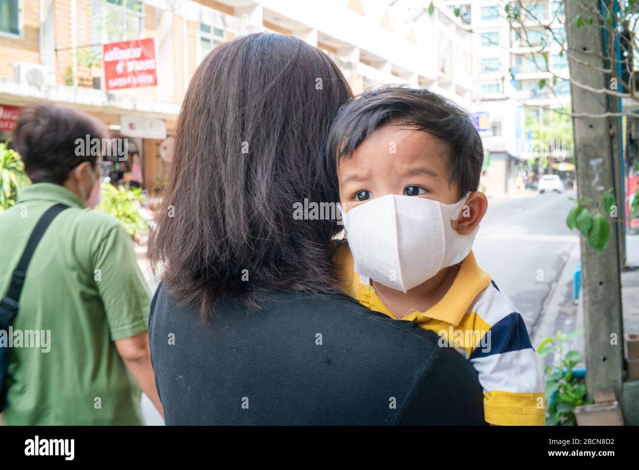 Asian cute boy and mother wearing N95 mask outdoor city building ...
