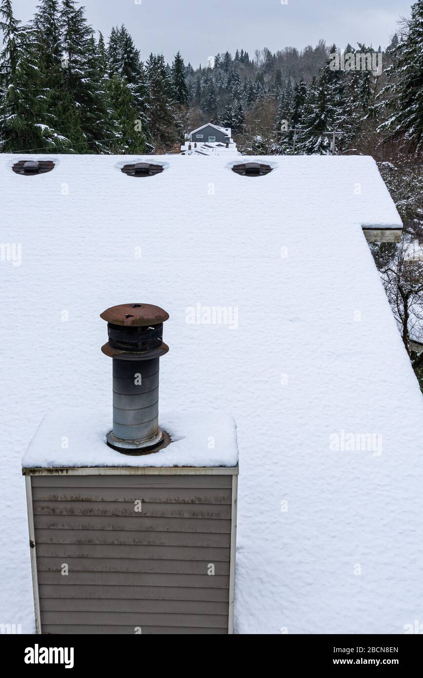 House rooftop covered in snow, rusty chimney vent, roof vents, wood ...