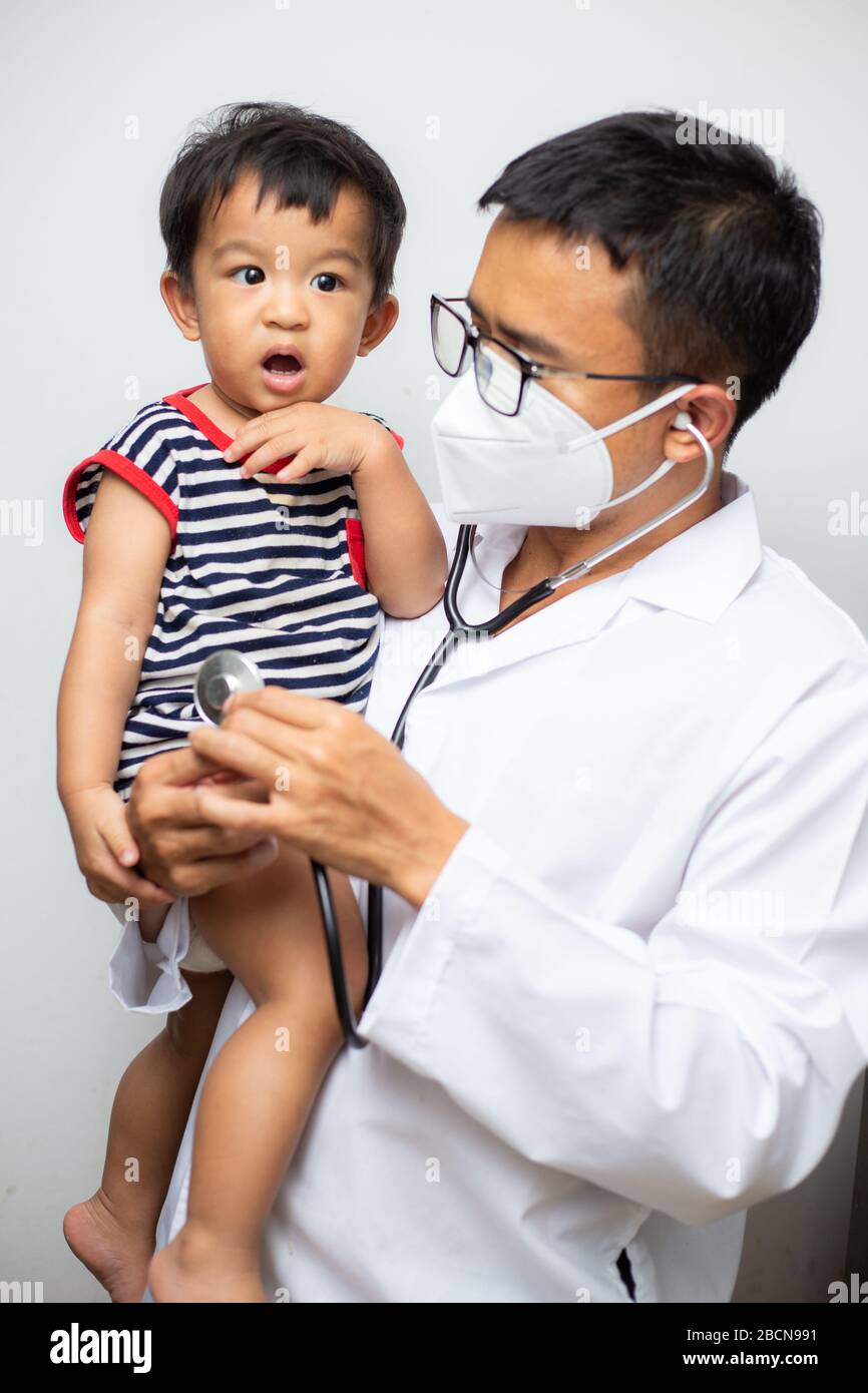 Cheerful asian pediatrician doing a medical checkup corona virus of a ...