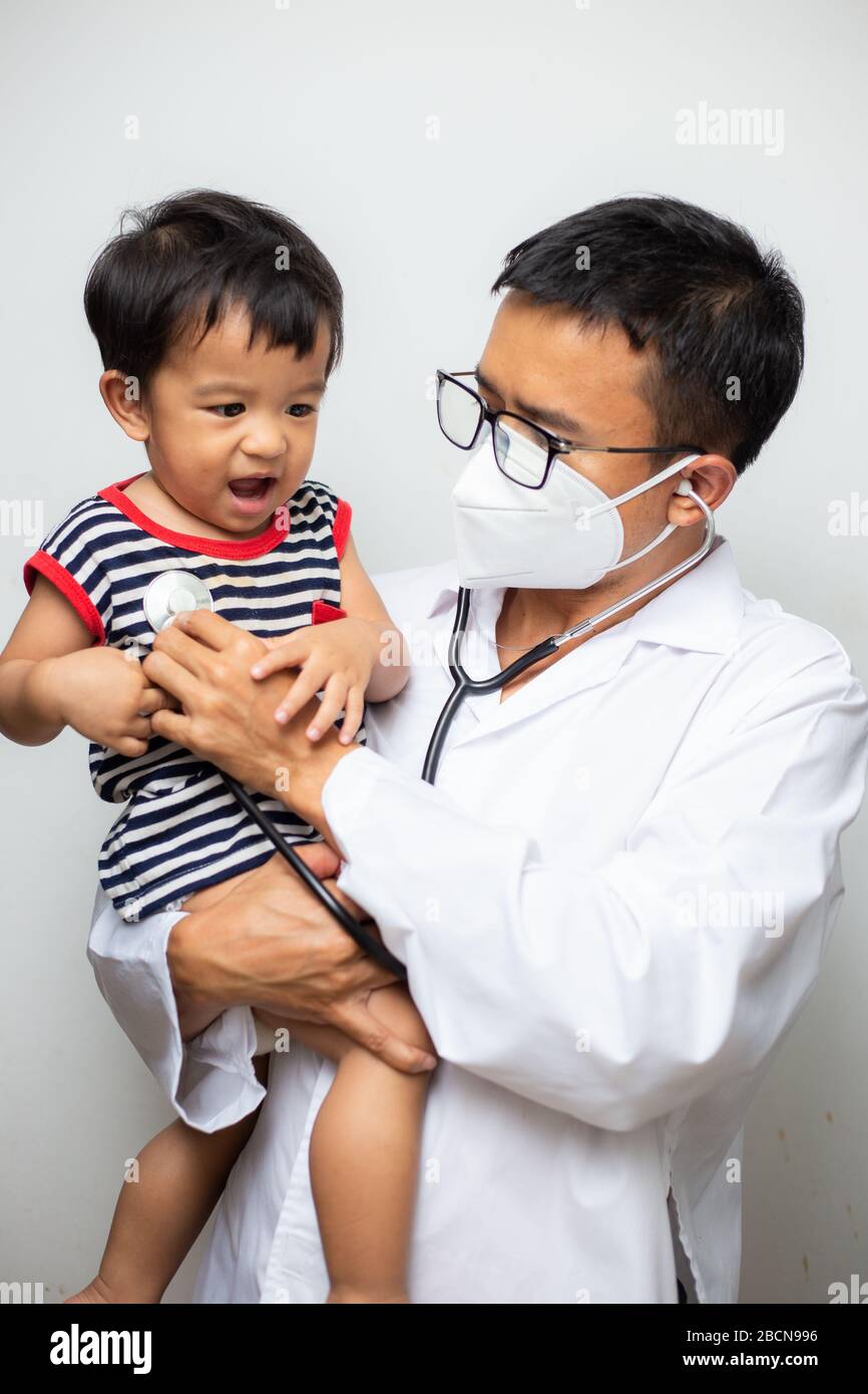 Cheerful asian pediatrician doing a medical checkup corona virus of a ...