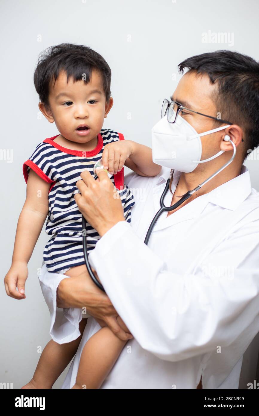 Cheerful asian pediatrician doing a medical checkup corona virus of a ...