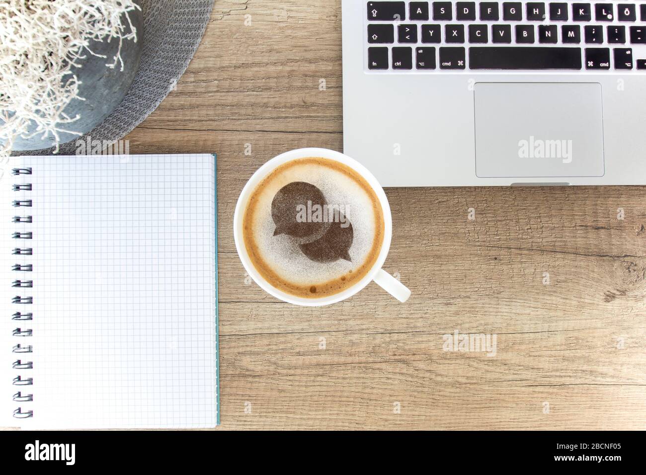 Coffee mug on a rustic table with chat web icon, laptop and notepad ...