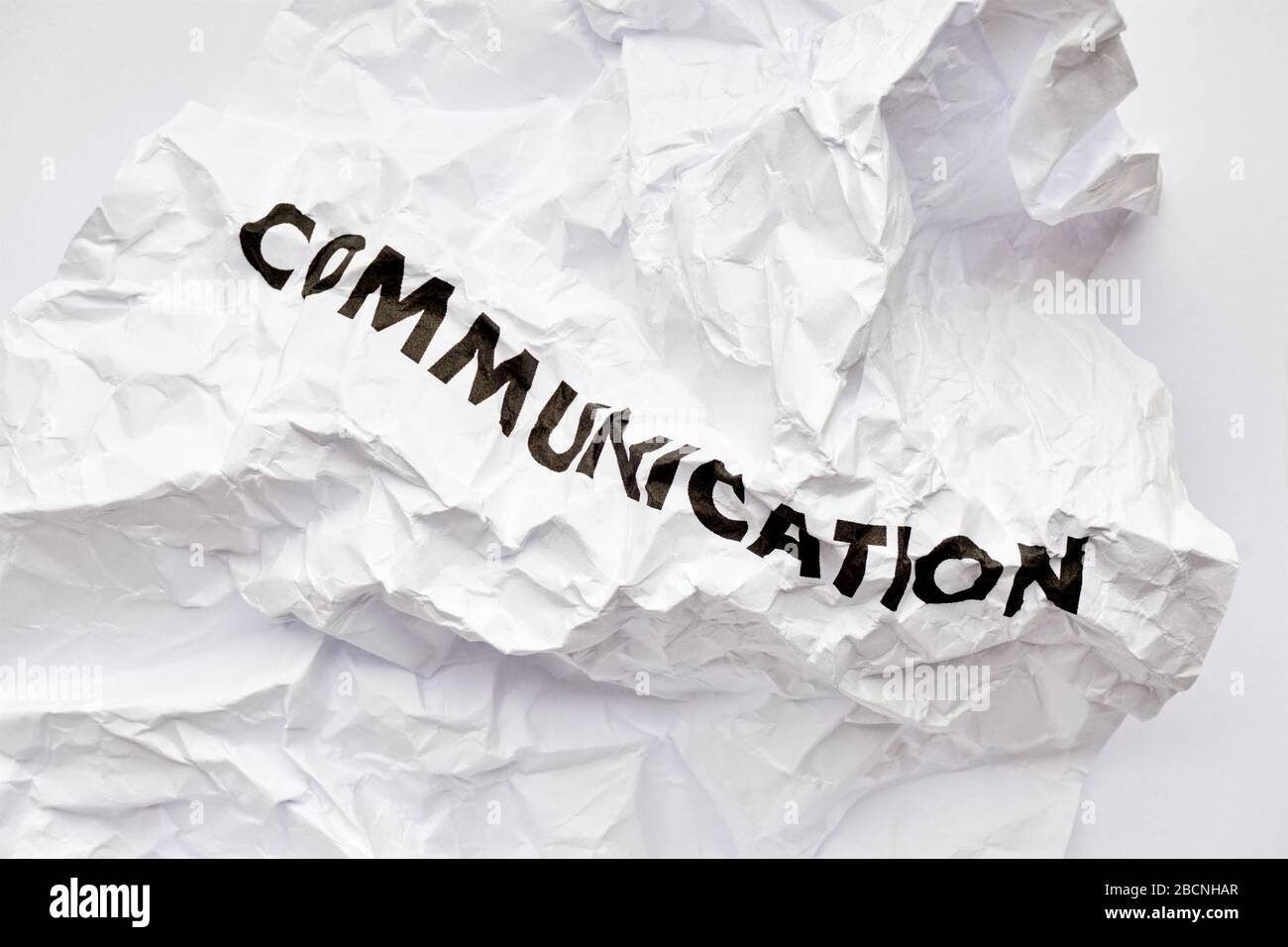 Wrinkled white paper with the word communication printed in black ...