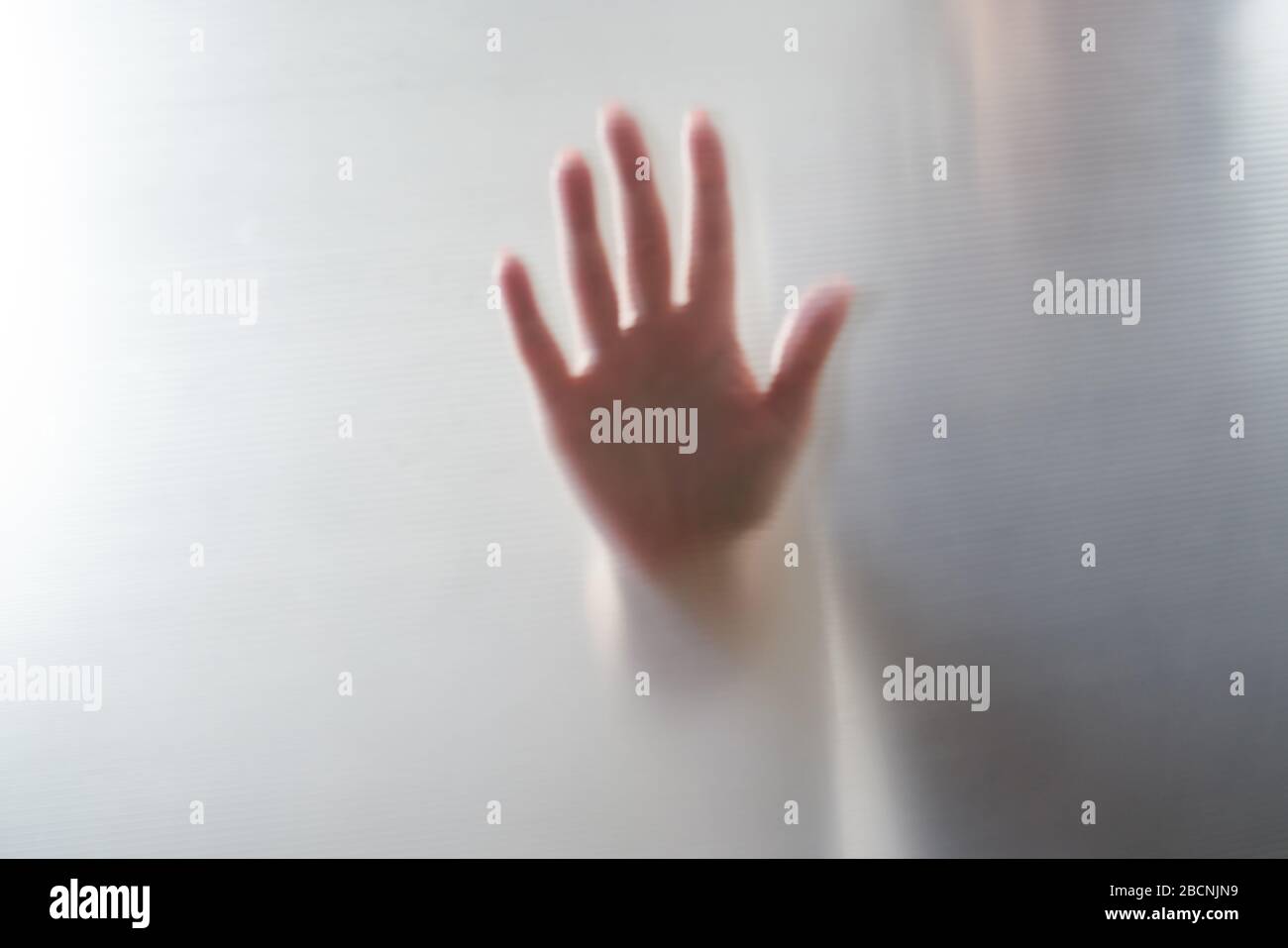 Diffused silhouette of female hands, view with shadow through plastic ...