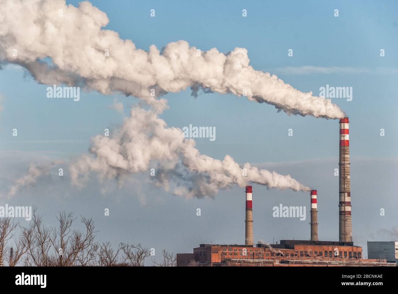 Old factory chimneys with white smoke against a blue sky Stock Photo ...
