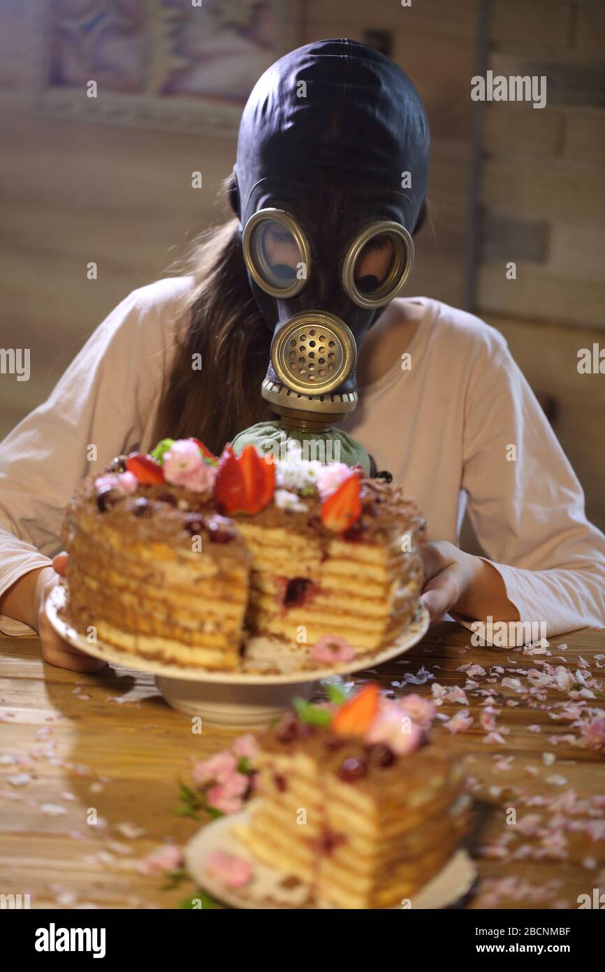 Girl in a gas mask holds a piece of cake Stock Photo - Alamy