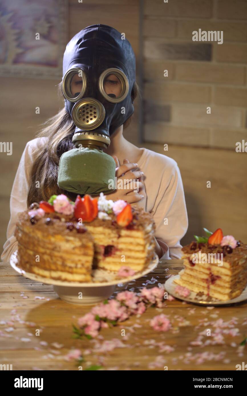 Girl in a gas mask holds a piece of cake Stock Photo - Alamy