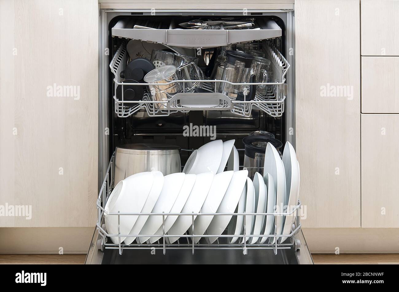 Full loaded Dishwasher machine. Integrated Dishwasher with white plates ...