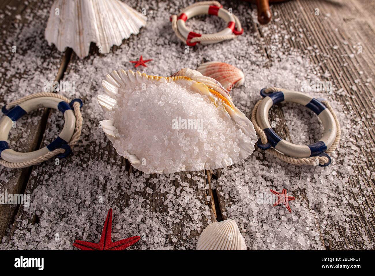 Sea salt crystals in the sea shell on wooden background Stock Photo - Alamy