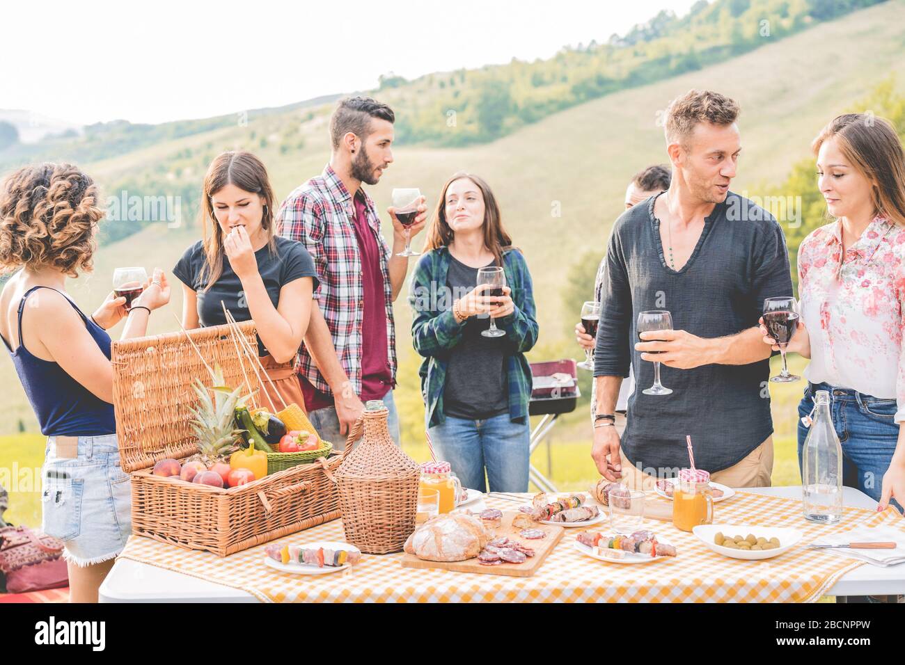 Happy adult friends eating at picnic lunch in italian vineyard outdoor ...