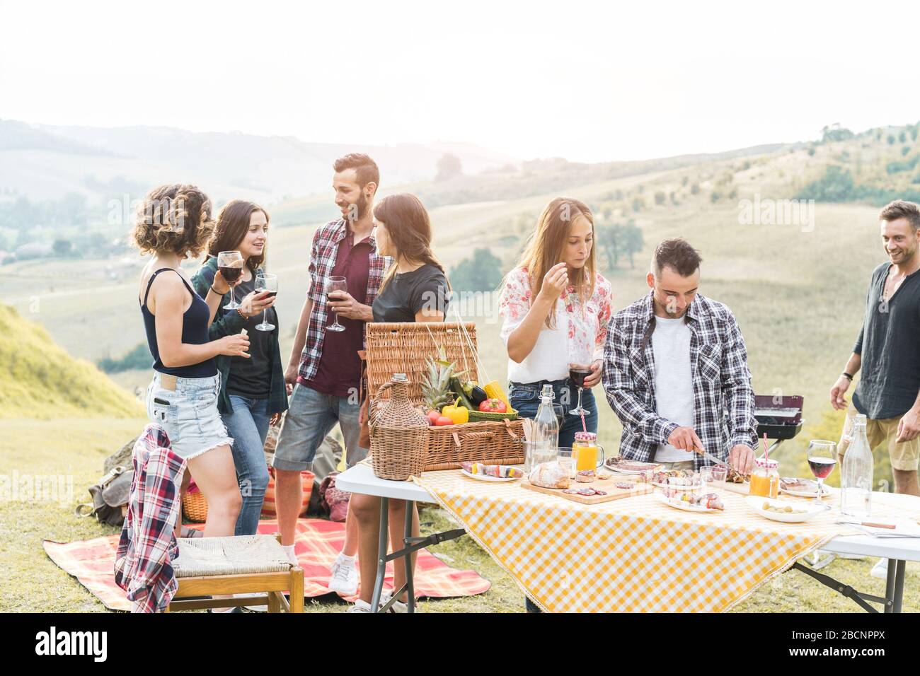 Happy friends eating at picnic lunch in italian vineyard outdoor ...