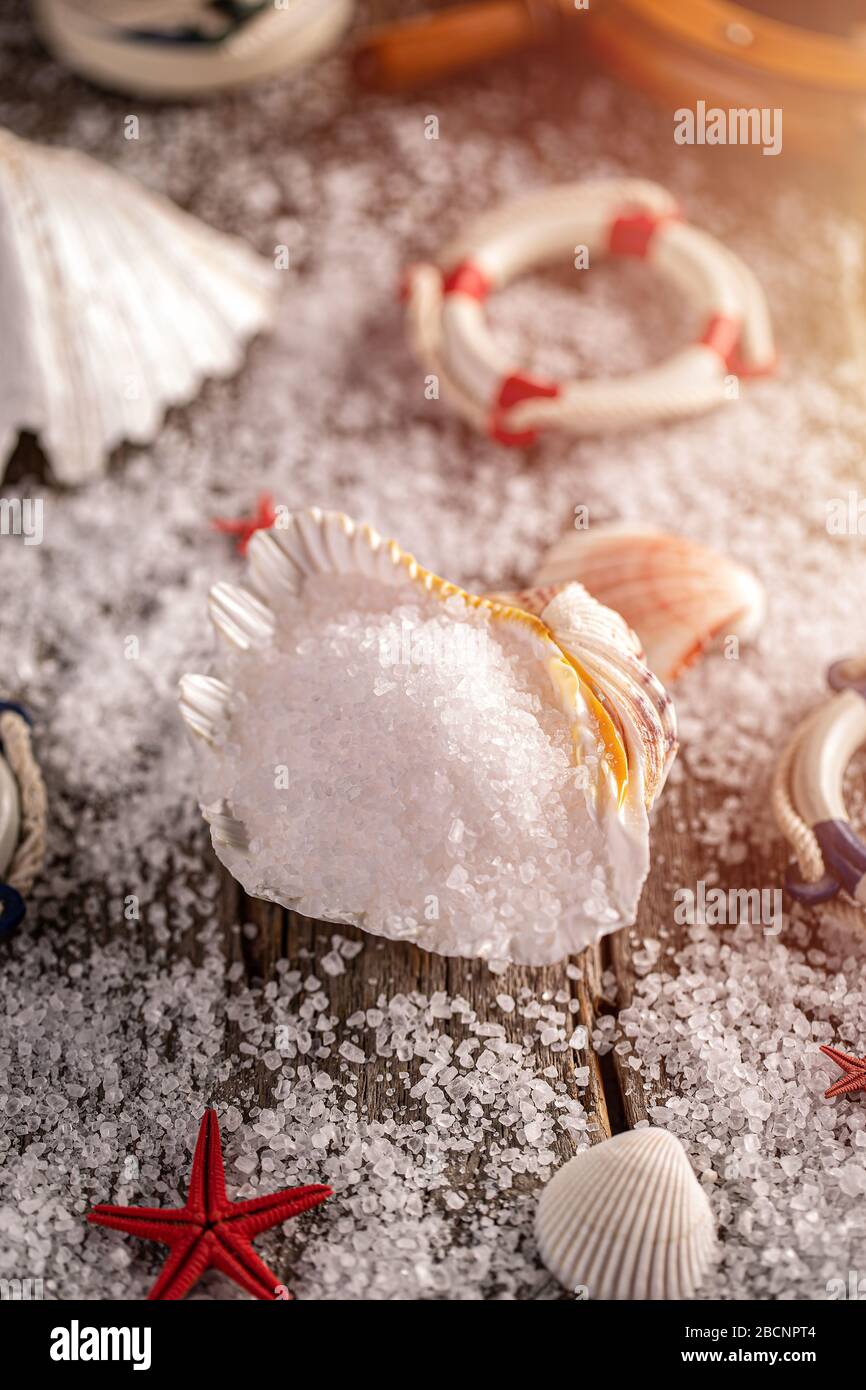 Pile of sea salt in shell on wooden background Stock Photo - Alamy