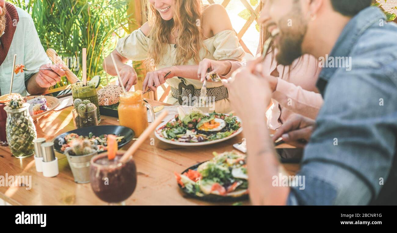 Hands view of young people eating brunch and drinking smoothies bowl ...