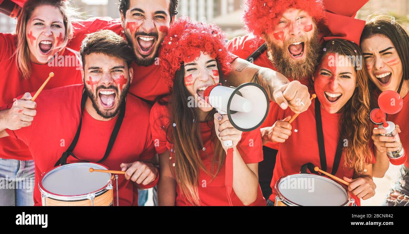 Red sport fans screaming while supporting their team out of the stadium ...
