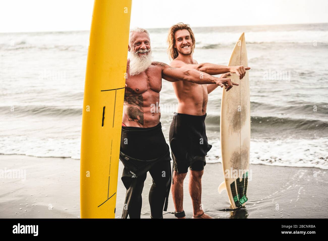 Multigeneration friends going to surf on tropical beach - Family people ...