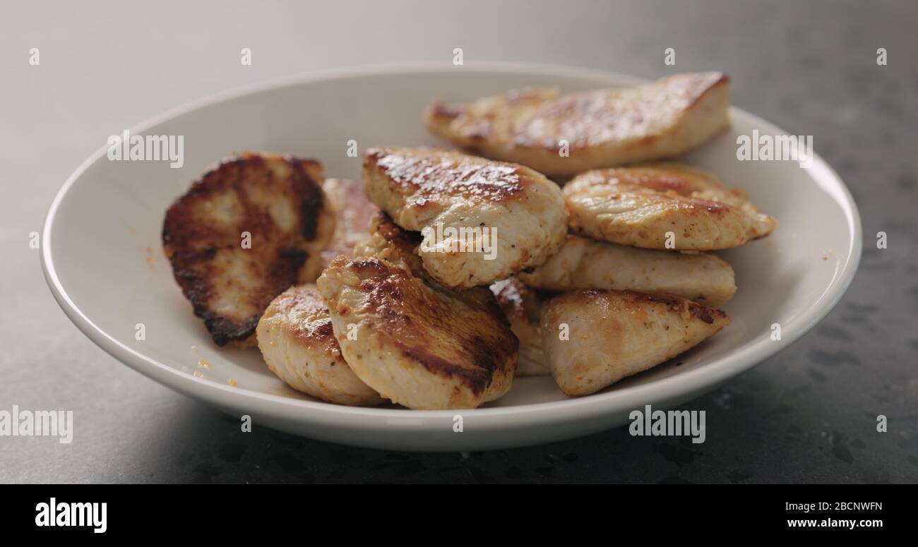 fried turkey fillet pieces falling into white bowl from pan Stock Photo ...