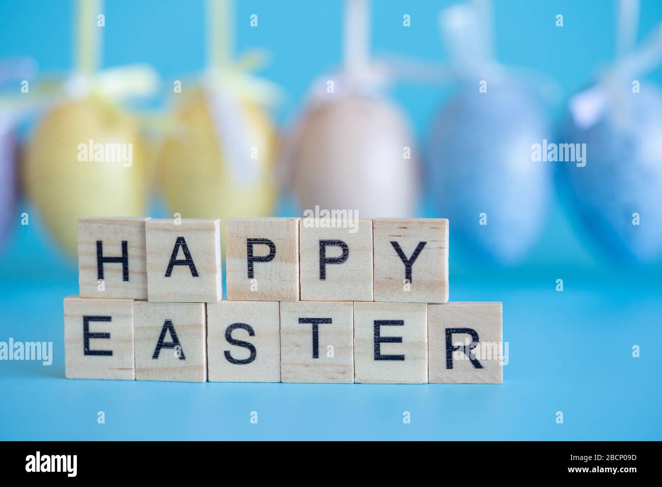 Happy Easter text made of wooden letters on a turquoise background ...