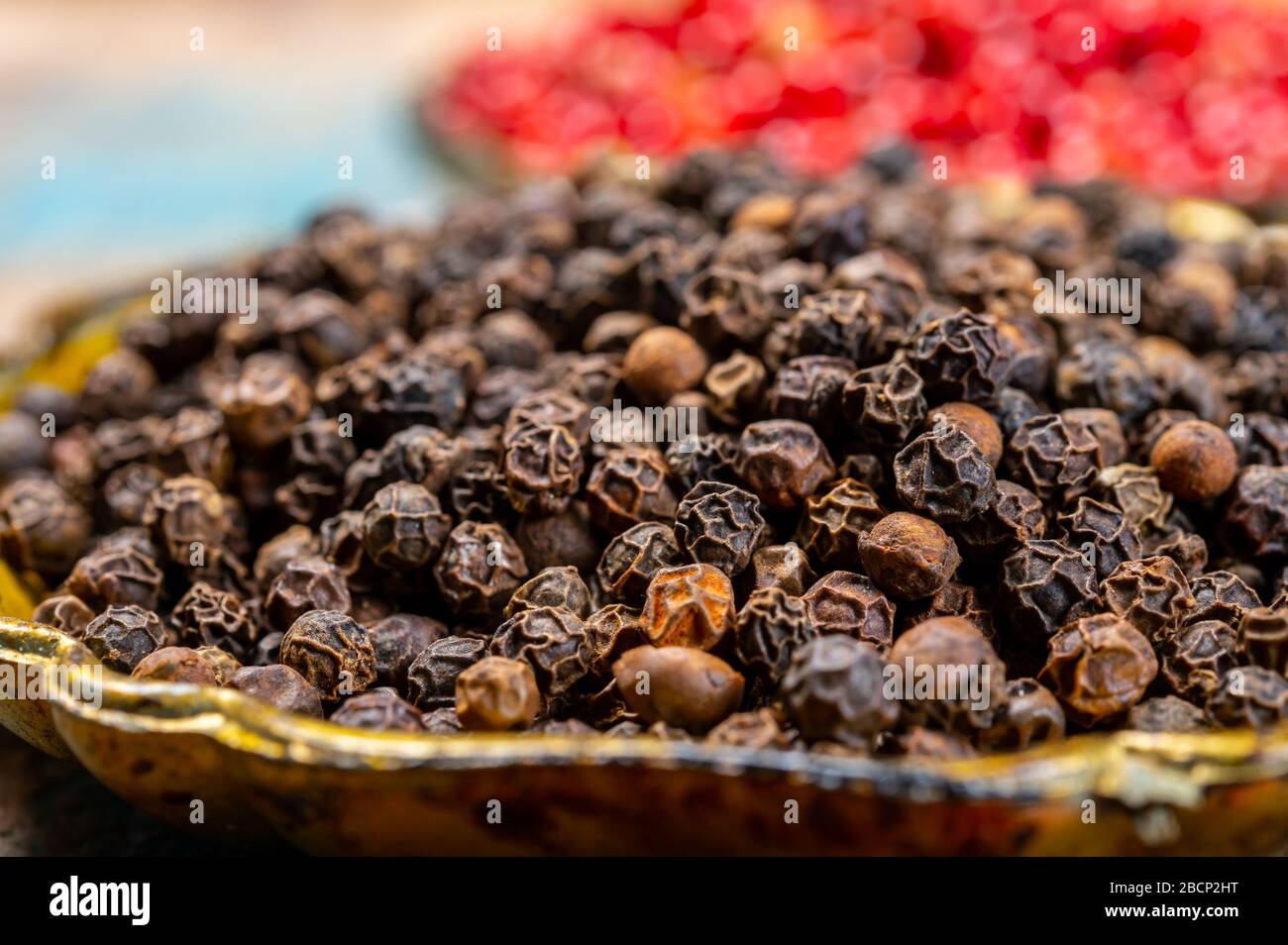 Bowl with dried black and red round peppers condiment close up Stock ...