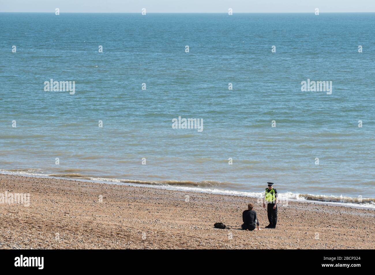 Police speak to a man who resused to leave Brighton Beach during the ...
