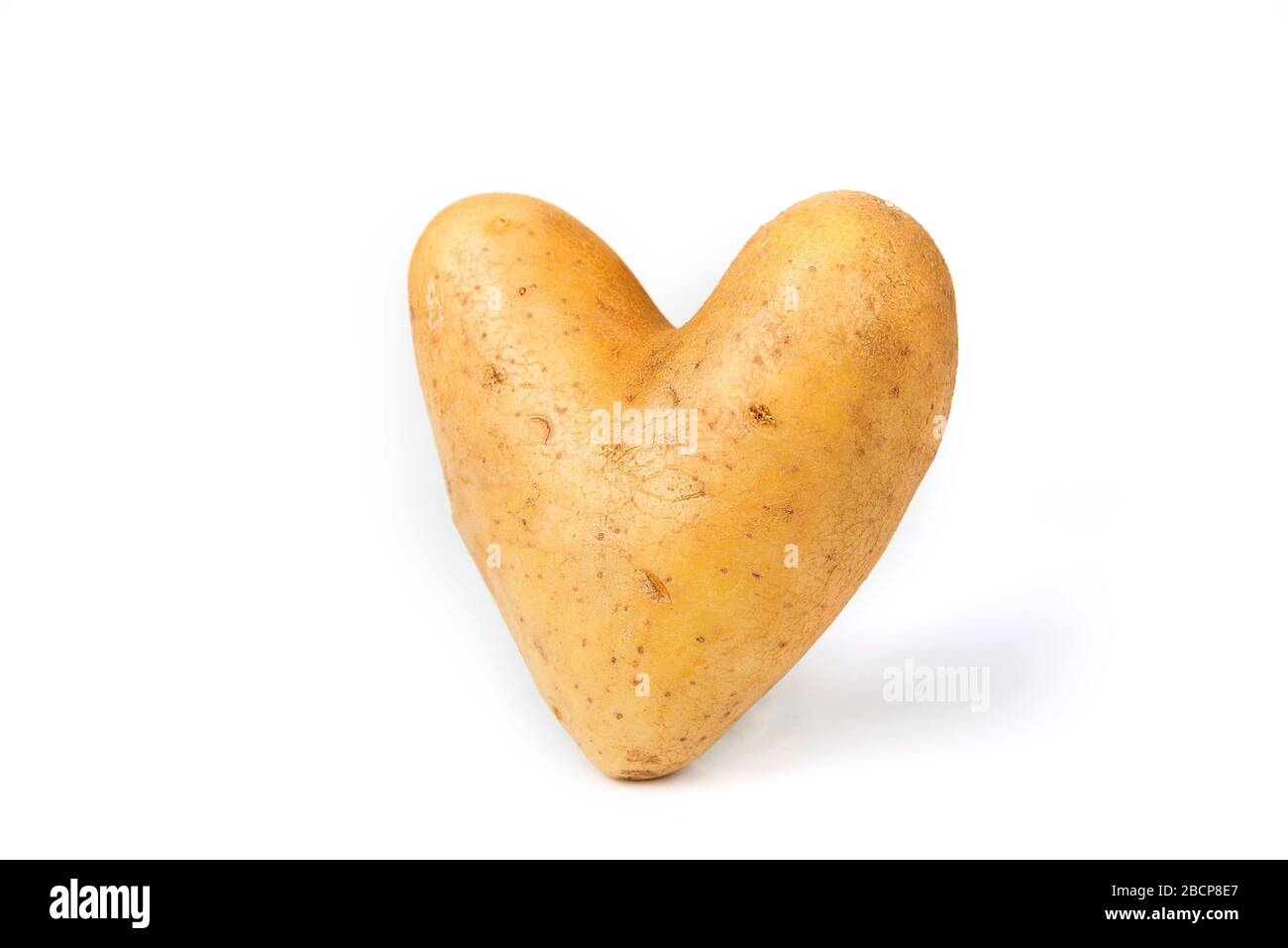 Potato in the heart shape on a white Stock Photo - Alamy