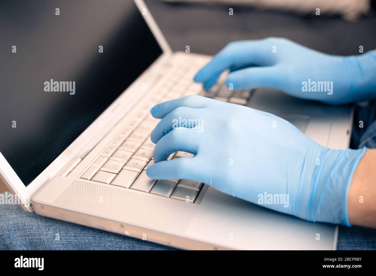 Using computer protected with gloves during coronavirus pandemic Stock ... Using computer protected with gloves during coronavirus pandemic Stock ...