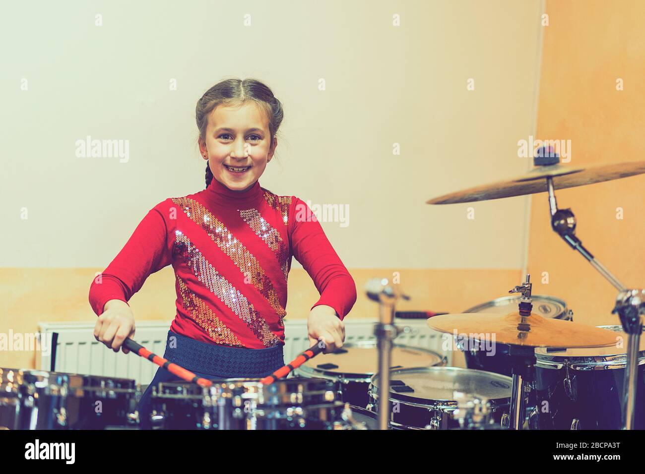 happy girl playing the drums. Teen girls are having fun playing drum ...