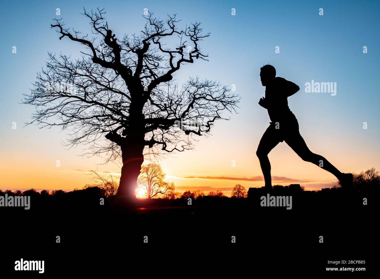 A runner keeping fit (under lock down for Corona virus Covid 19 restrictions) on a sunny ...