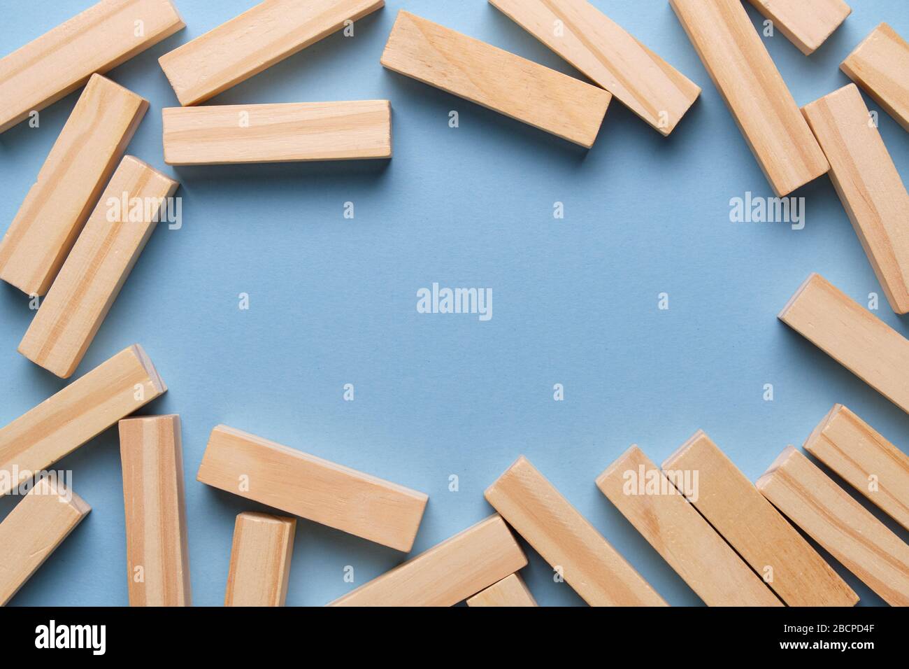 Wooden blocks on a blue background for copy space in center. Close up ...