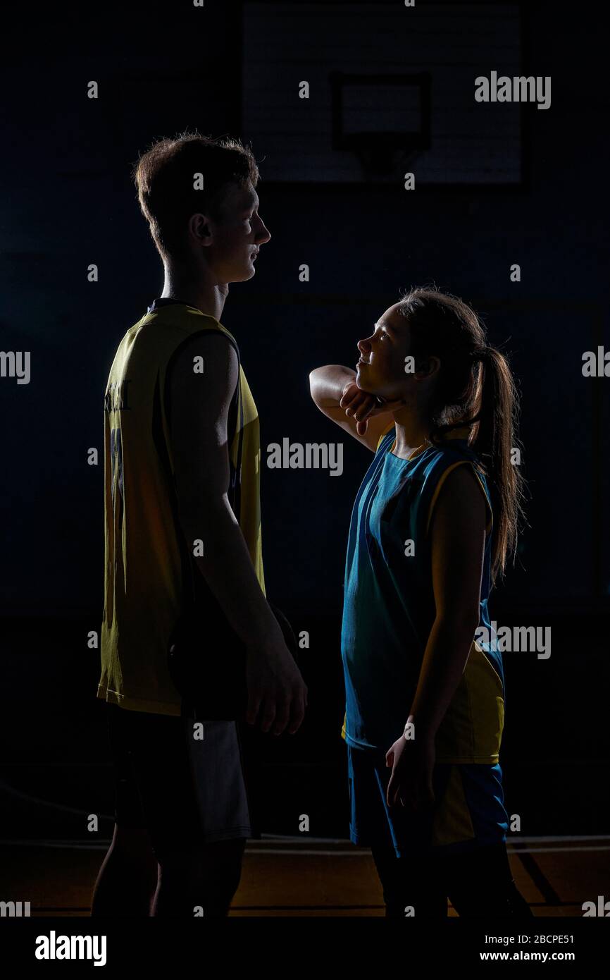 A boy and a girl face each other before starting a game of basketball ...