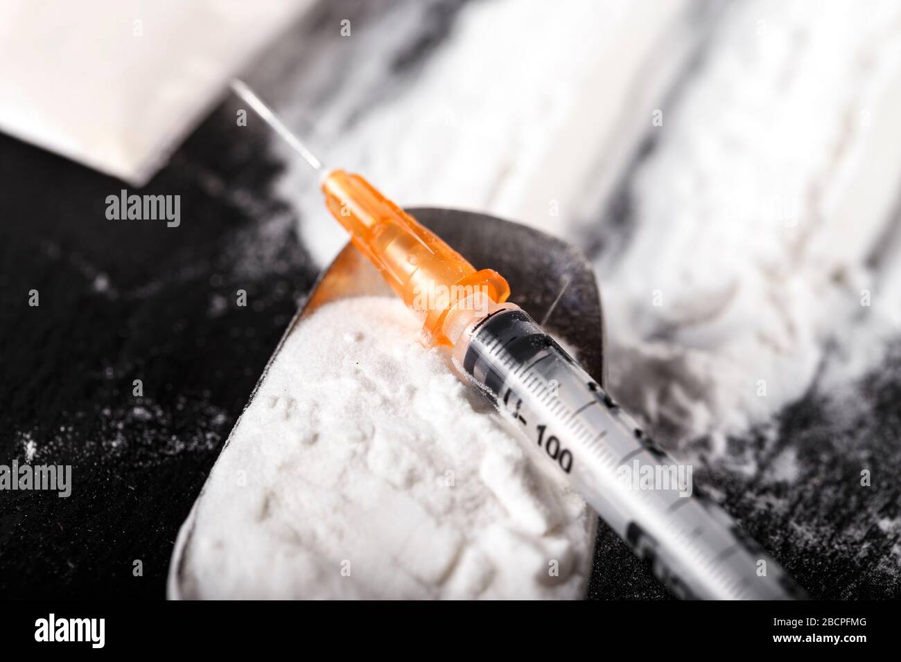 drug white powder sprinkled on a black table. next syringe. dangerous ...