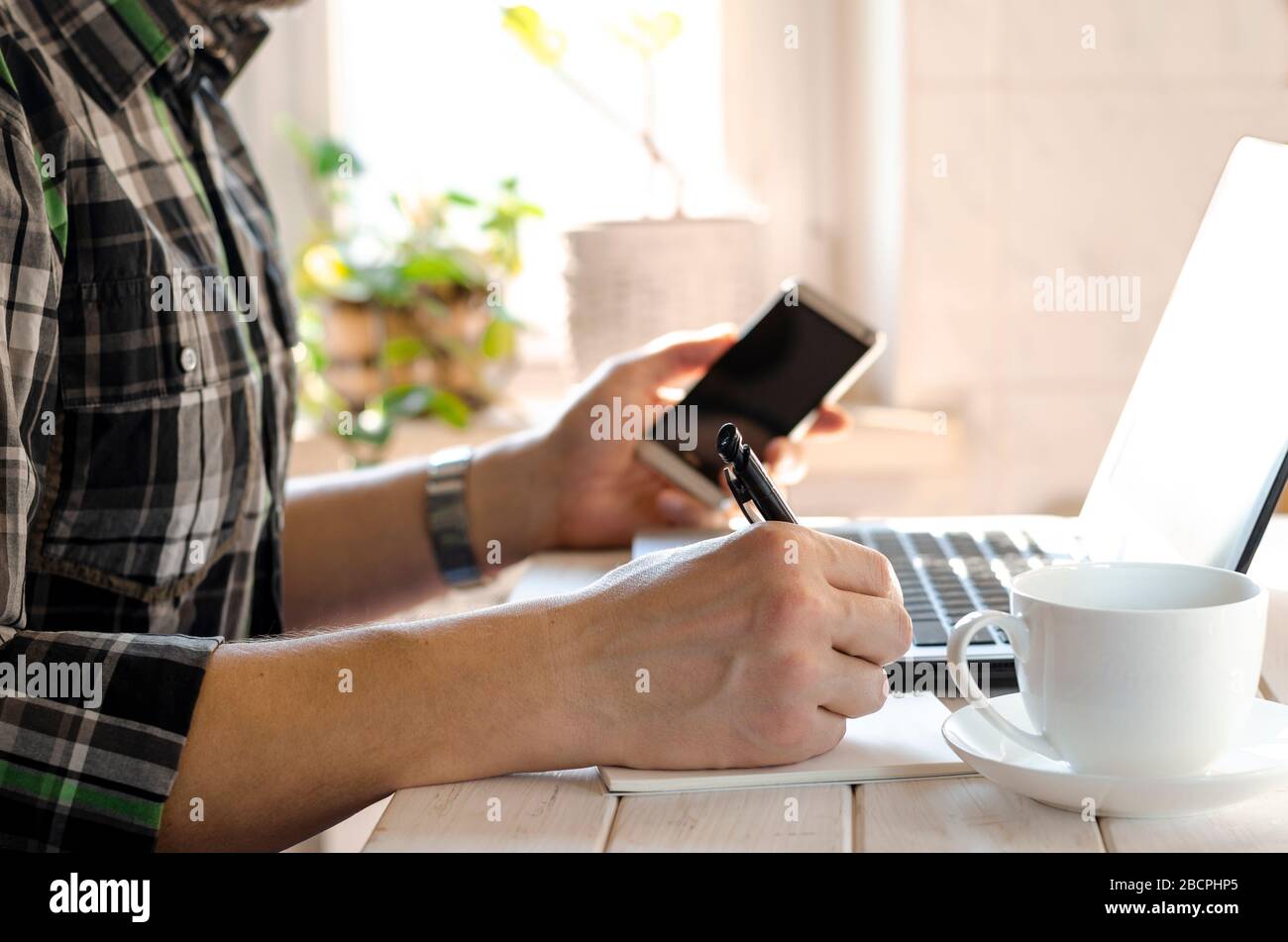 Freelancer works in the home office sitting at the desk near the window ...