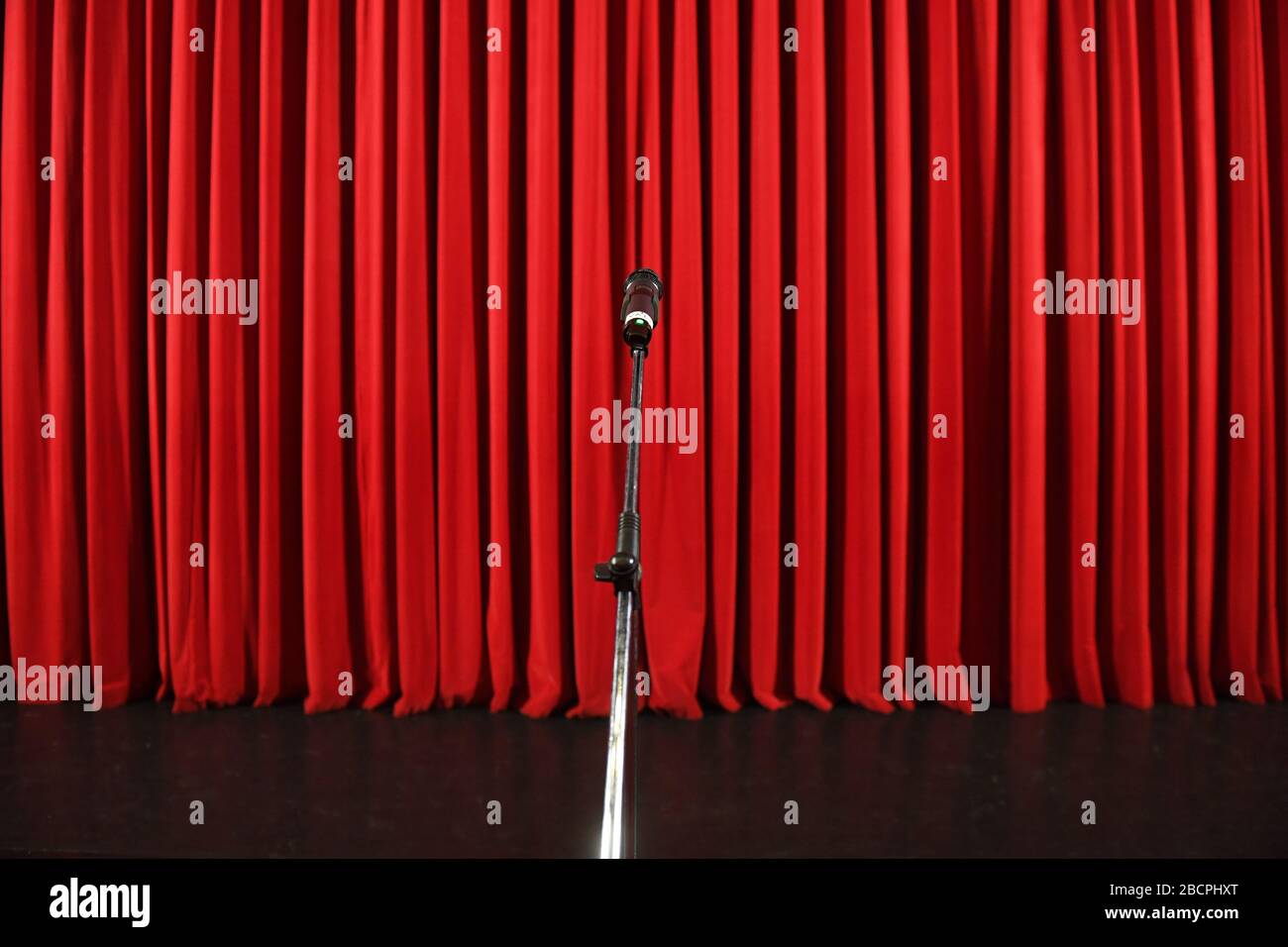 Microphone in front of a red curtain Stock Photo - Alamy