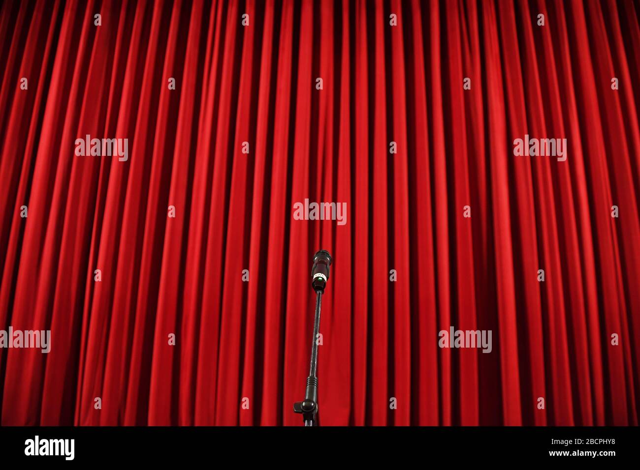 Microphone in front of a red curtain Stock Photo - Alamy