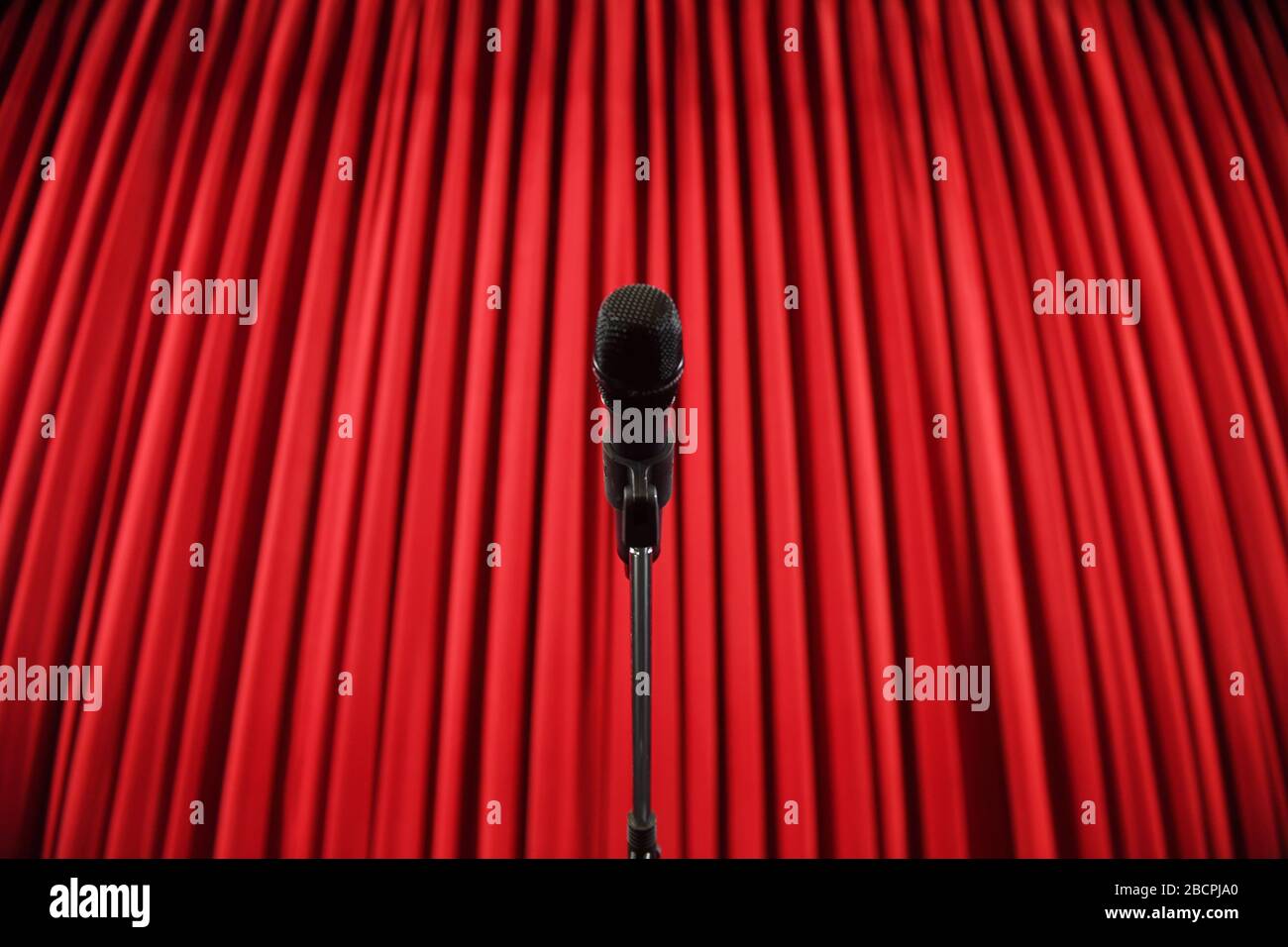 Microphone in front of a red curtain Stock Photo - Alamy