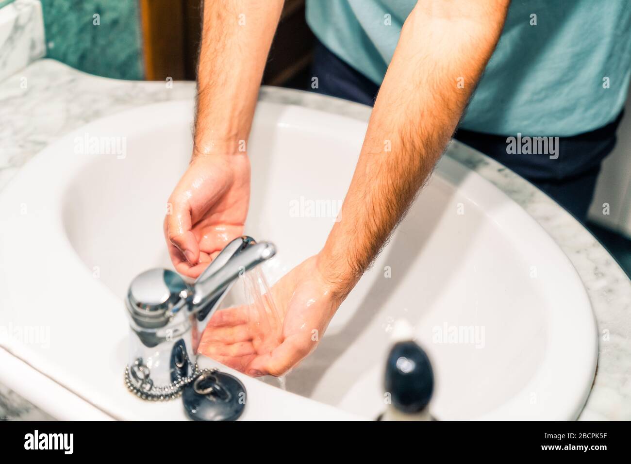 Washing your hands at a sink to prevent coronavirus infection. Tap on ...